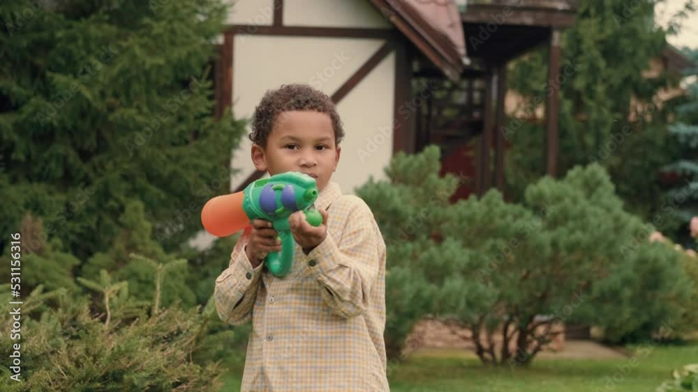 Portrait of an African child with a water gun in his hands near the ...
