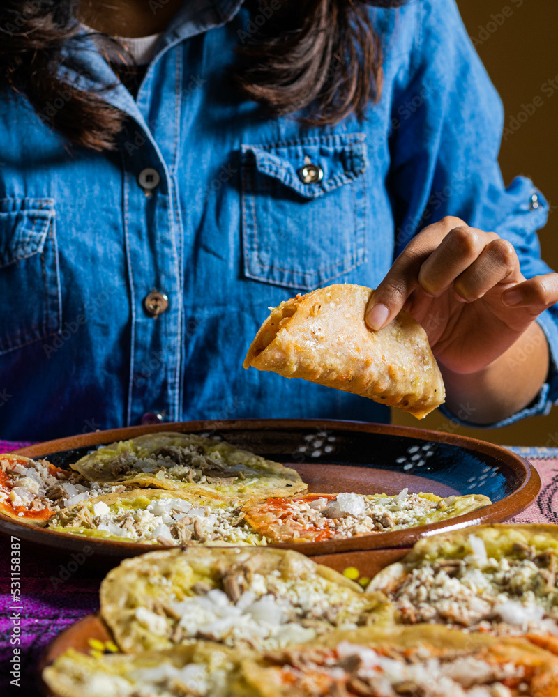 person eating mexican food, corn tortillas with green sauce and red ...