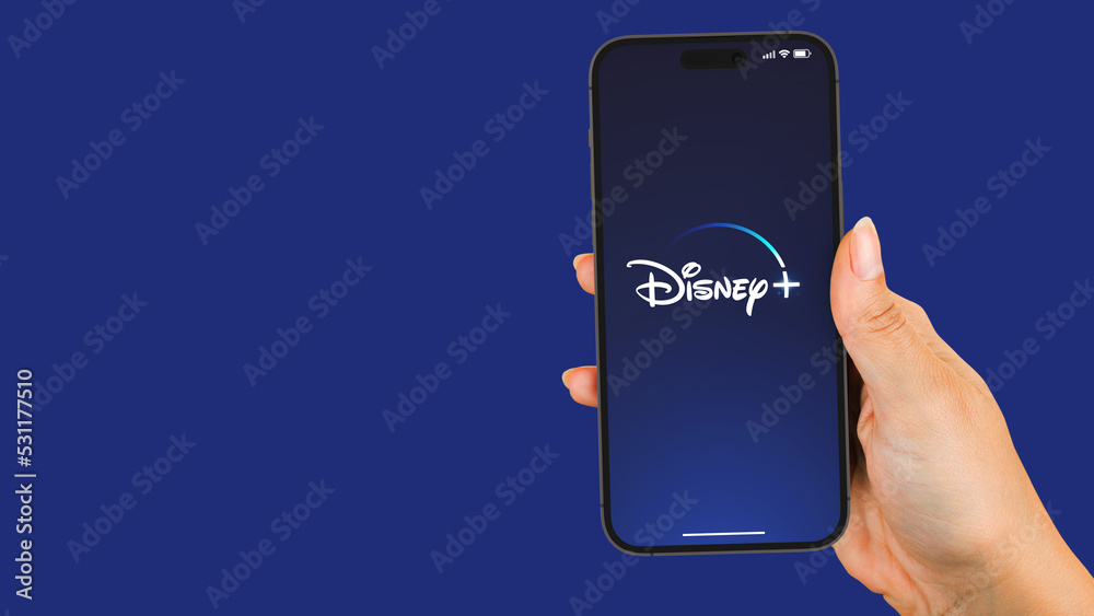 Female hand holding a smartphone iPhone 14 Pro with Disney Plus ...