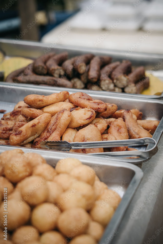 Trays of sweets at a market in Laos, focus is on the banana fritters ...