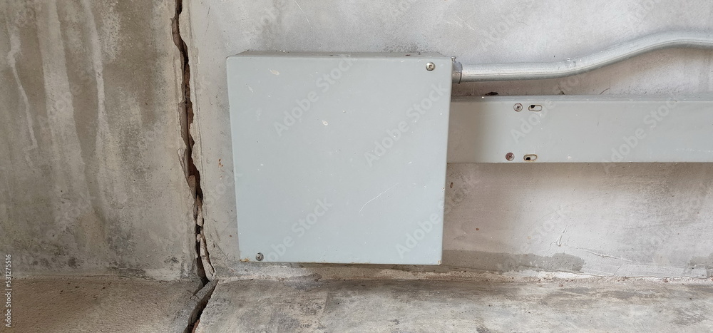 Cracks in the cement wall with long and deep lines near the electrical ...