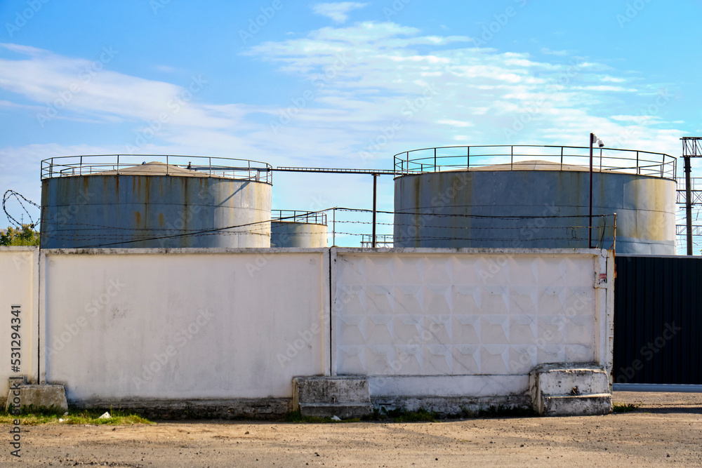 Foto de old abandoned oil and fuel storage facilities behind a concrete ...