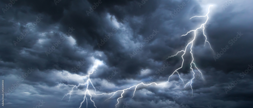 The dark sky with heavy clouds converging and a violent lightning storm ...