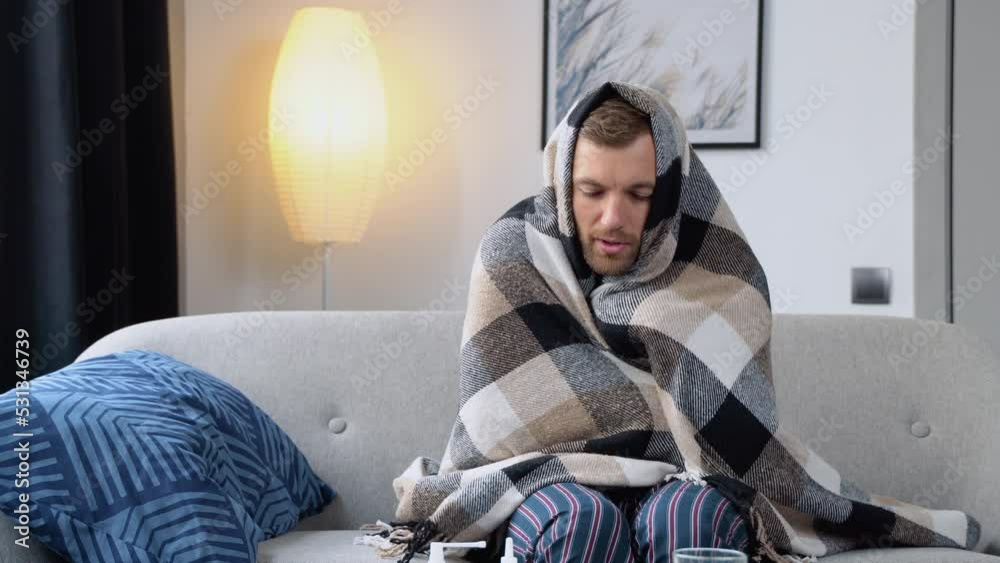 Young man suffering from a common cold and flu or allergy sit at home ...