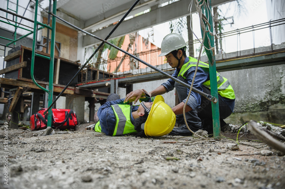 First aid support accident at work of builder worker in construction site. Accident falls from ...