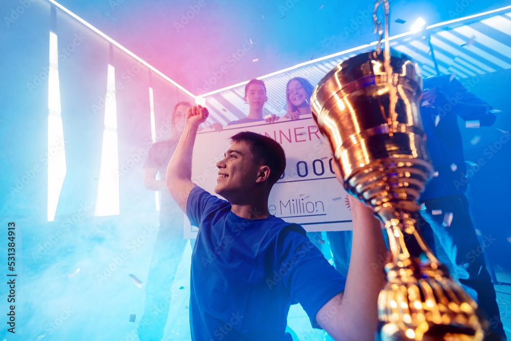 Winner team gamer, happy young man holding cup trophy prize of victors ...