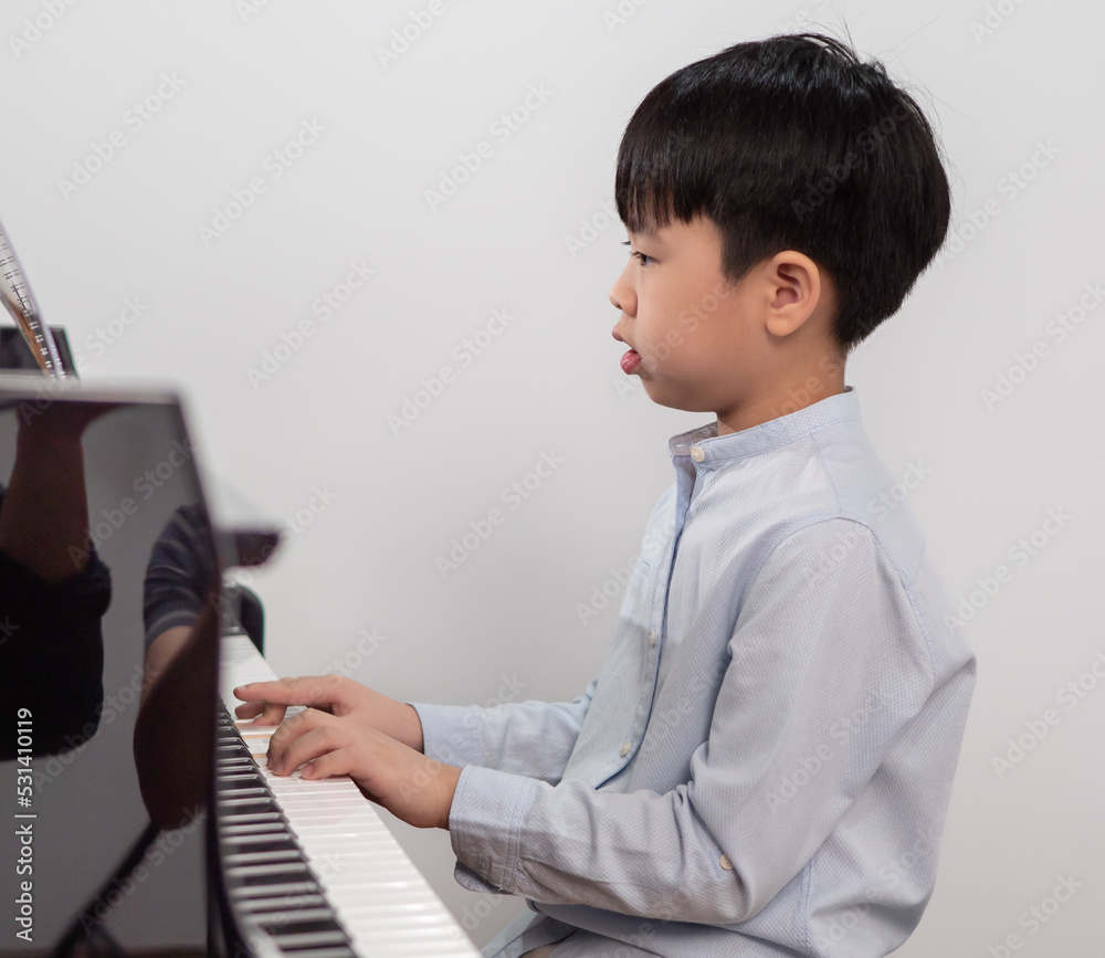 Little talent child sitting at grand piano playing classical music. Boy ...