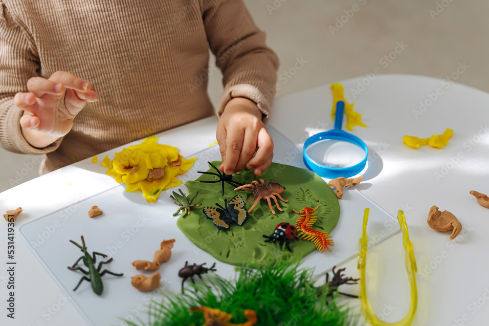 Child hands playing with toy insects. Educational game Bug Fossils made ...