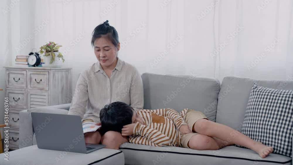 4K, Asian boy playing tablet, He lies on lap Asian single mother, who ...