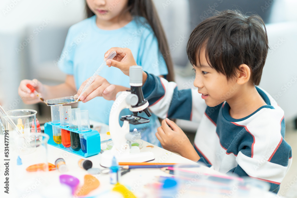 Kid playing a microscope for scientific experiments at home.Young ...