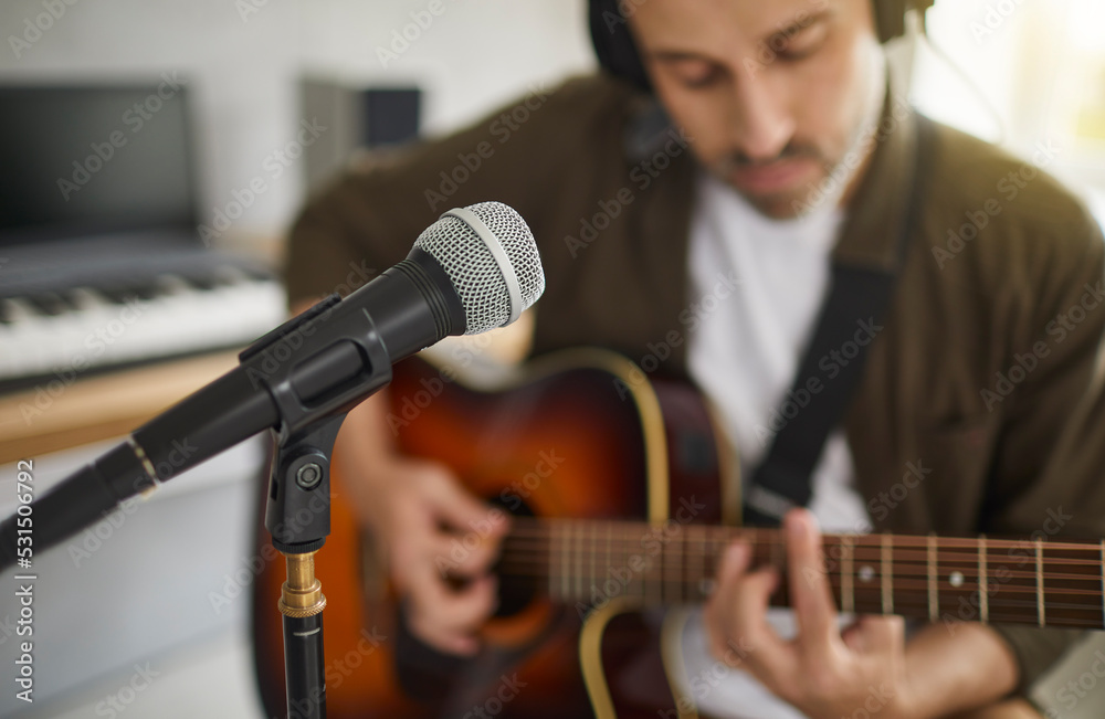 Man playing acoustic guitar and singing into microphone. Close up shot ...