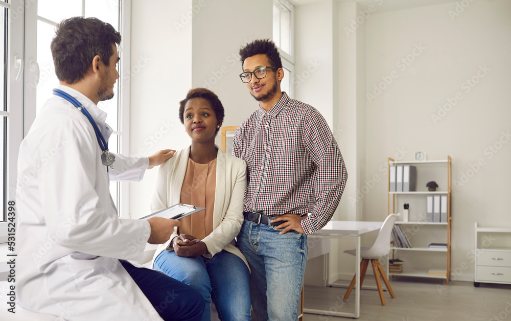 Foto de Young couple visiting doctor for professional consultation and ...