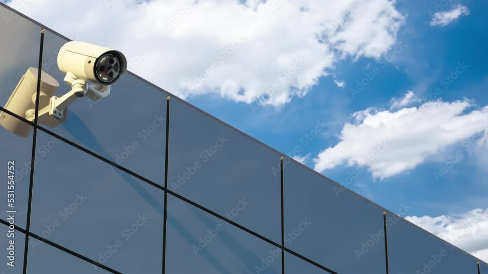 CCTV camera installed on wall of the building and Sky Time-lapse ...