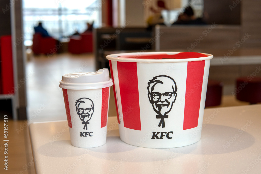 KFC basket with fried spicy chicken and KFC cup of tea stand on the ...