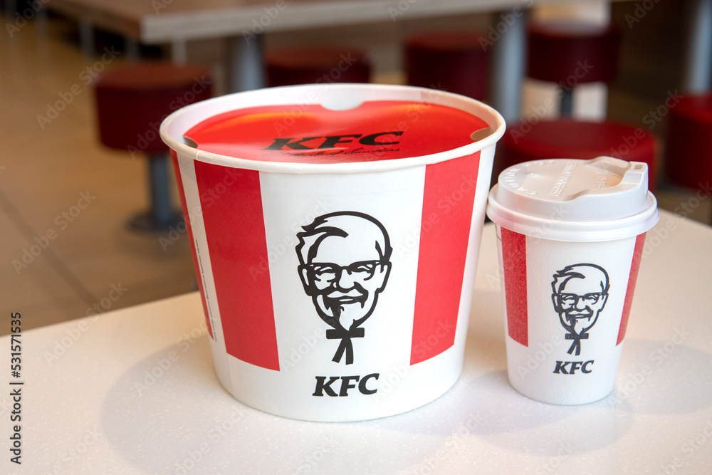KFC basket with fried spicy chicken and KFC cup of tea stand on the ...