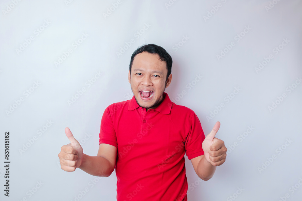 Excited Asian man gives thumbs up hand gesture of approval, isolated by ...