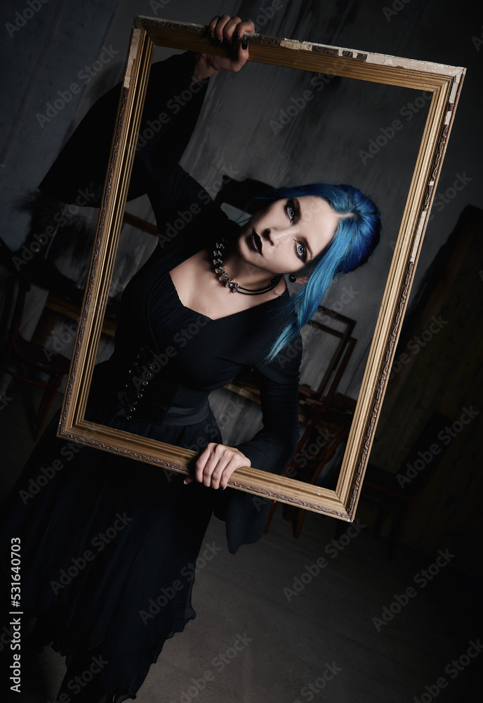 Indoors portrait of lovely goth girl in black dress. Blue-haired gothic ...