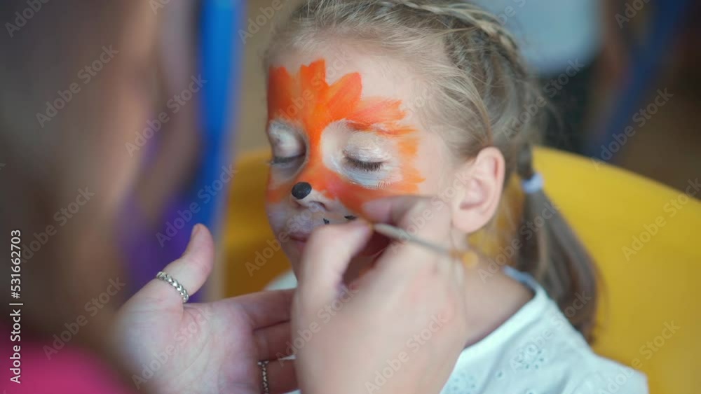 Children face painting. Artist painting with brash and special body ...