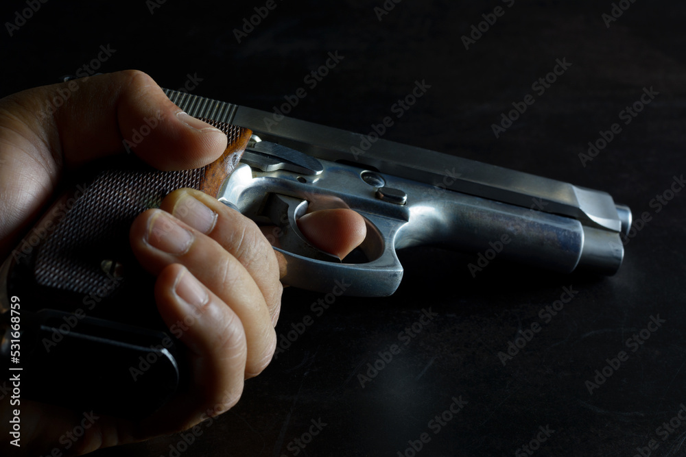 Left human hand holding gun. 9 mm parabellum semi automatic stainless ...