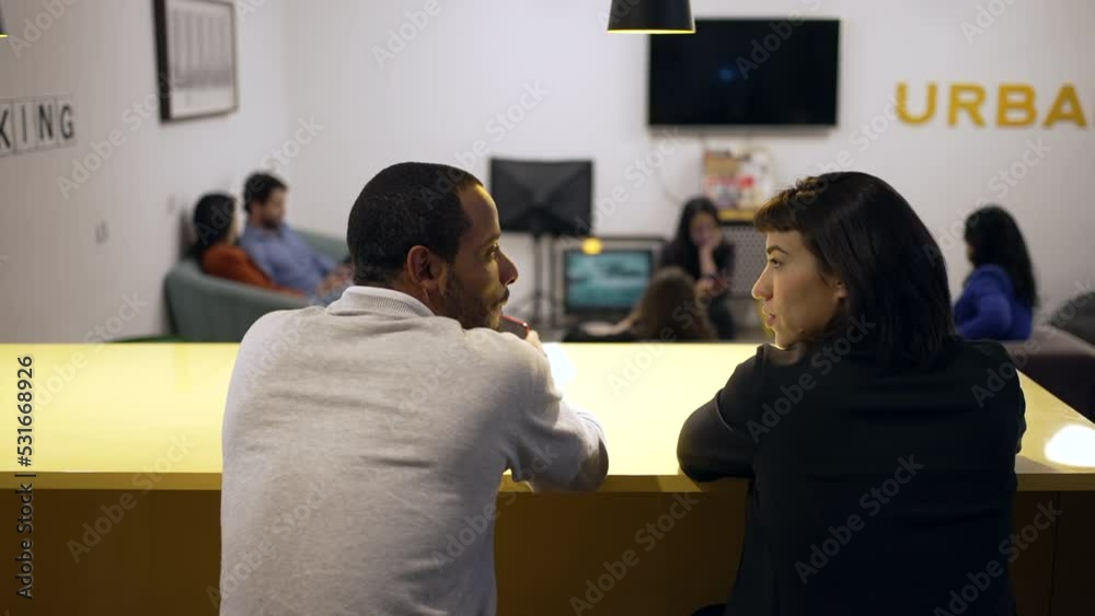 People conversing at workplace. Two diversed work colleagues talking at ...