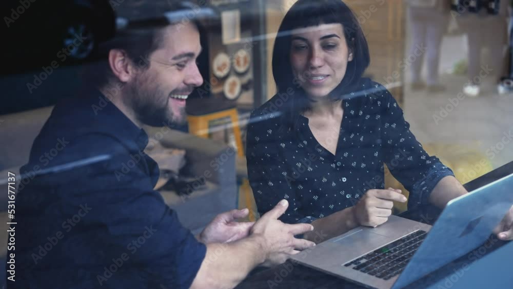 Two colleagues talking about work in front of laptop. Young man ...