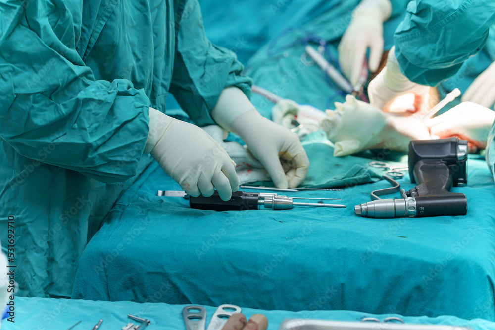 Assistant preparing instruments support Orthopedic doctor performing in ...