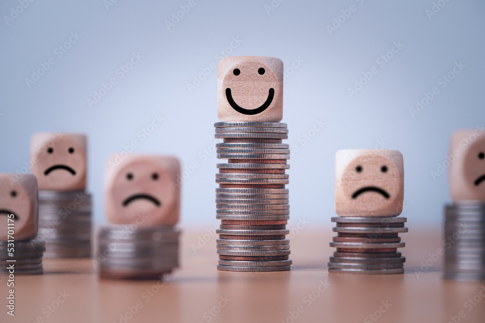 Coin stacking on smiley face and sad face for good financial planing ...