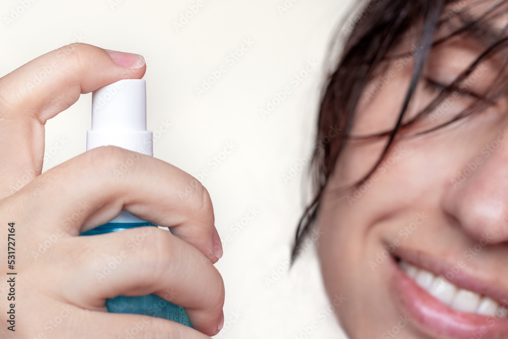 woman using spray on wet hair isolated.smiling girl with wet hair long ...