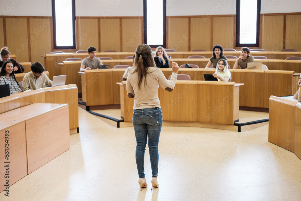 Teacher from behind giving classes to university students in an ...