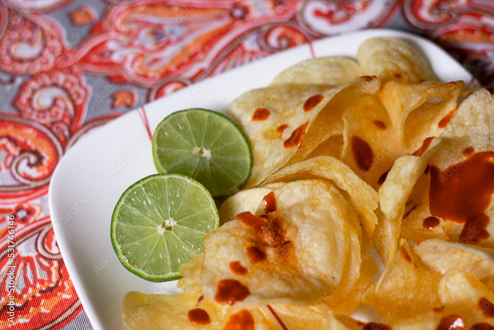 Papas fritas con salsa picante y limón partido Stock Photo | Adobe Stock