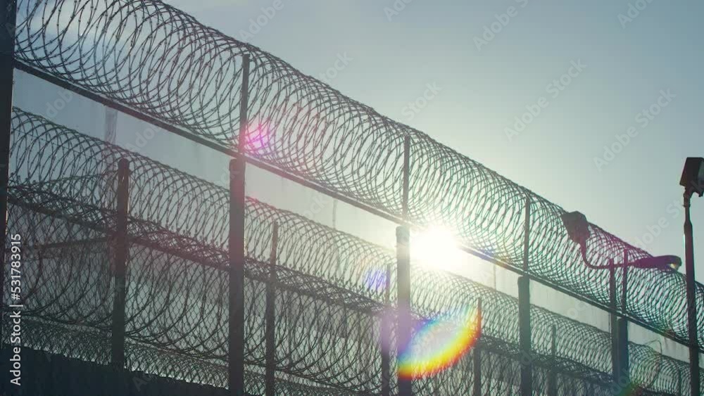 Overview of the electric chain-link fence with barbed wire of the ...