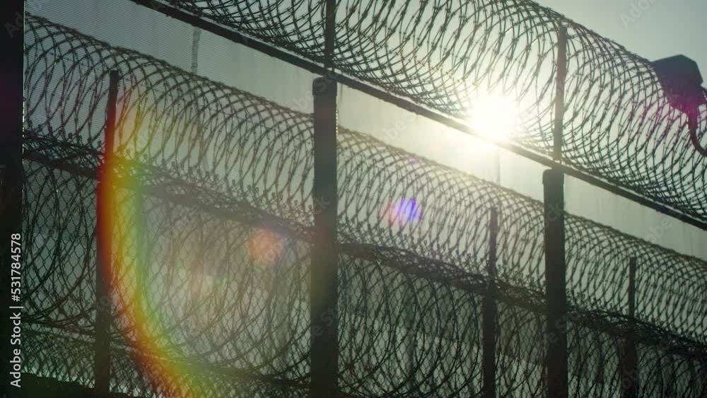 Overview of the electric chain-link fence with barbed wire of the ...
