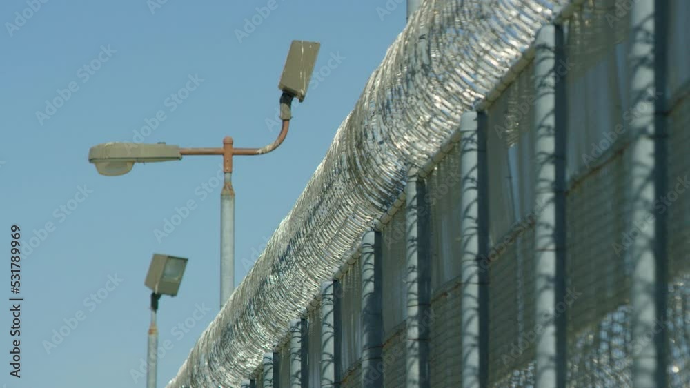 Overview of the electric chain-link fence with barbed wire of the ...