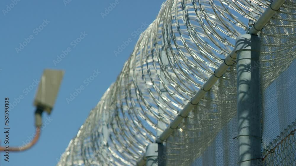 Overview of the electric chain-link fence with barbed wire of the ...