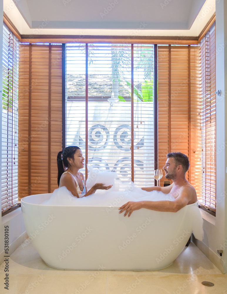 Couple of men and women in a bath, men and women in a white bathtub in ...