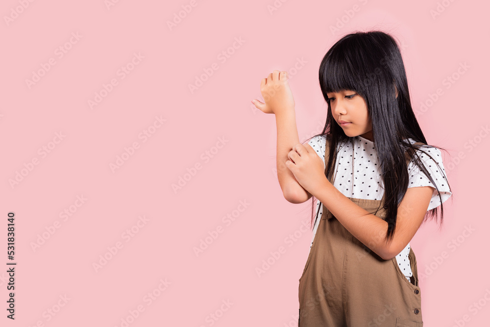 Asian little kid 10 years old scratching itch arm from a mosquito bite ...