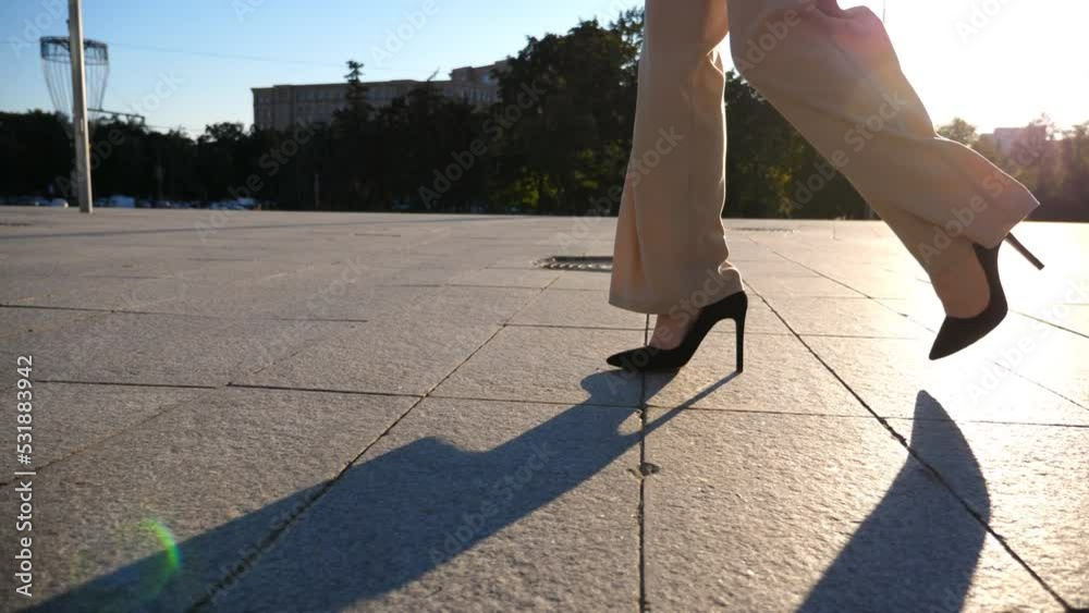 Female legs in high heels shoes walking in the urban street with sun ...