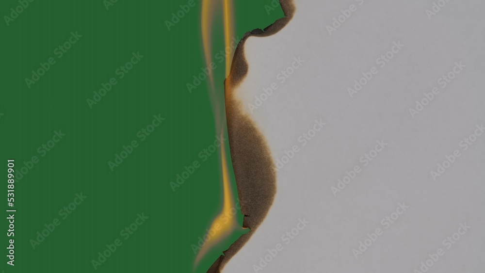 Flaming white sheet of paper with yellow flames and black charred edges ...