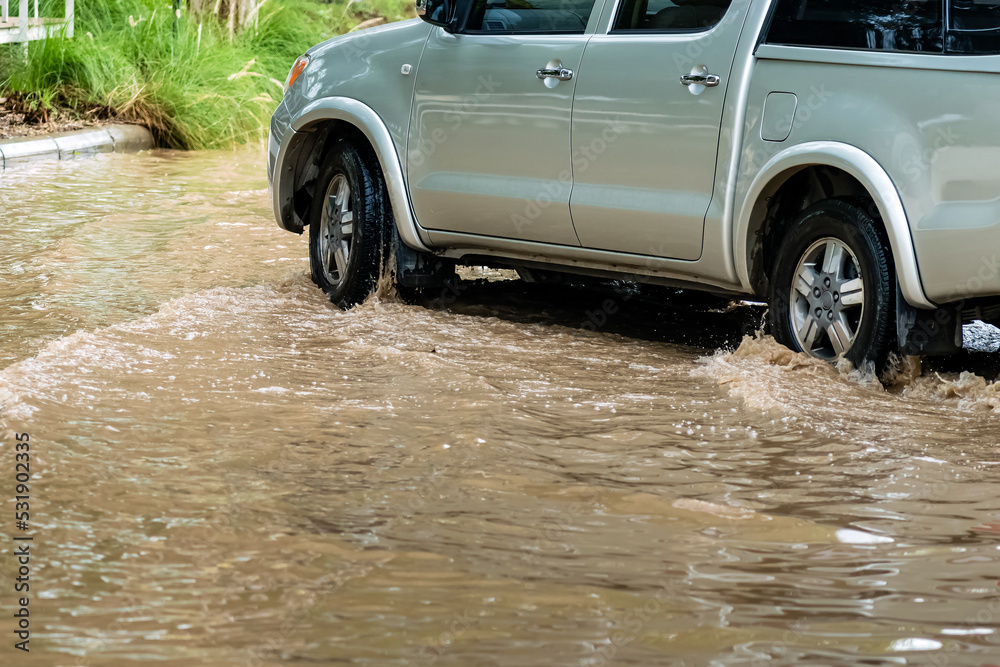 Pickup truck passing through flooded road. Driving car on flooded road ...