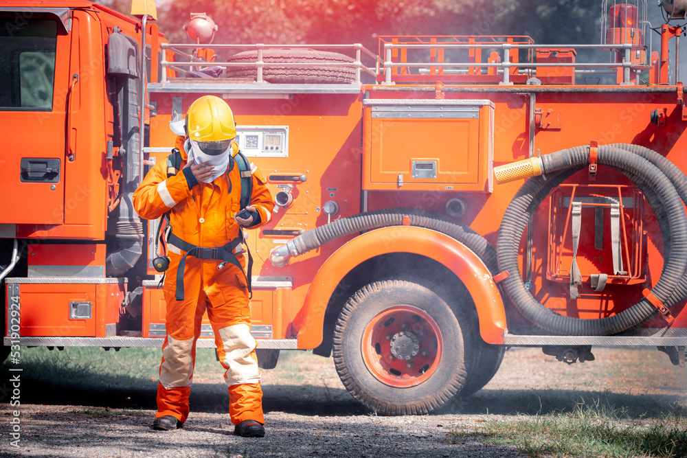 Firefighter man wearing protective fire suite and helmet with equipment ...