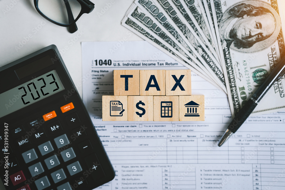 Tax text in wooden cubes and tax form documents to complete Individual ...