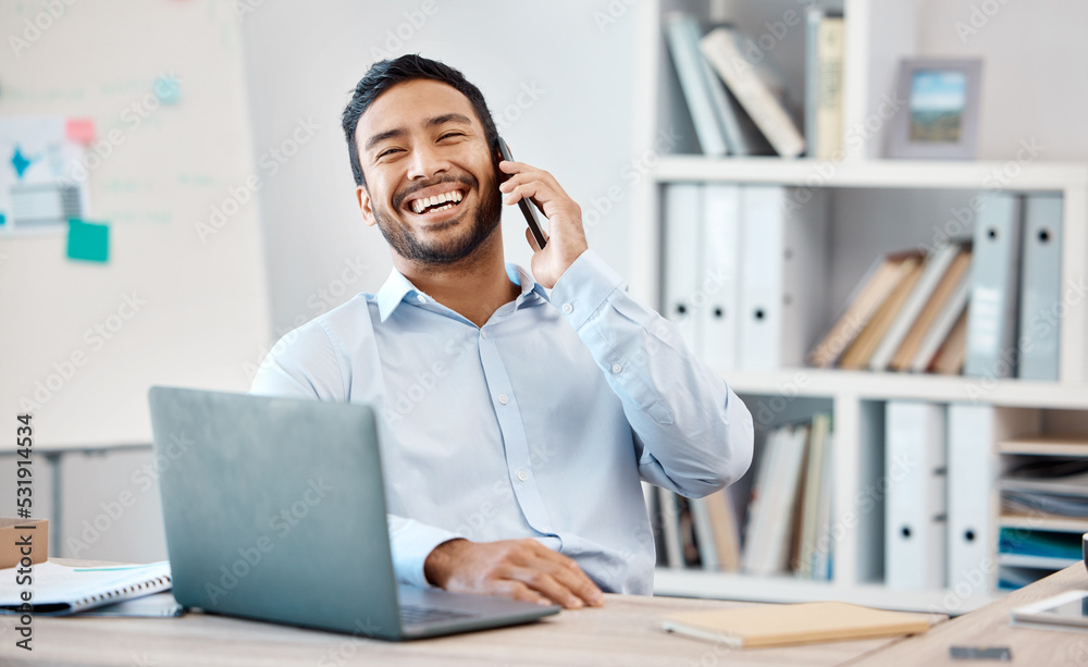Happy businessman on a phone call while working on a laptop at the desk ...