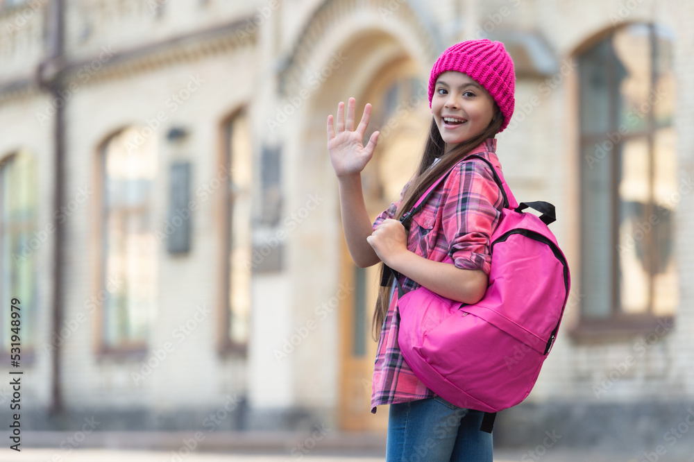 Happy teen girl back-to-school waving hand making hello or goodbye ...