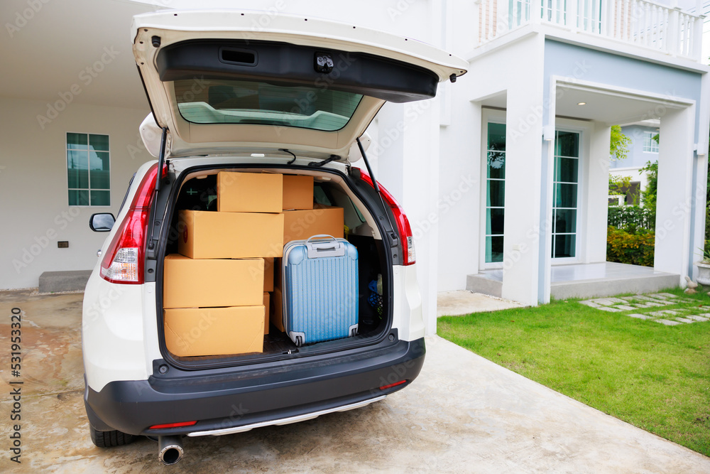 Moving Day. Many cardboard boxes and luggage in car that parking front ...