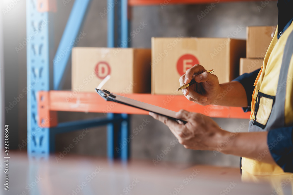 Male warehouse check worker checking and counting inventory accurately ...