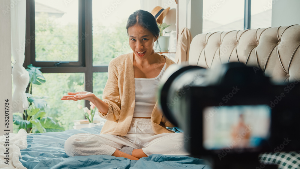 Happy Asian girl influencer with white cream pajamas recording sharing ...