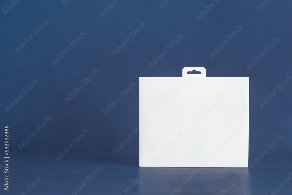 A white cardboard gift box on a colorful blue studio background with ...