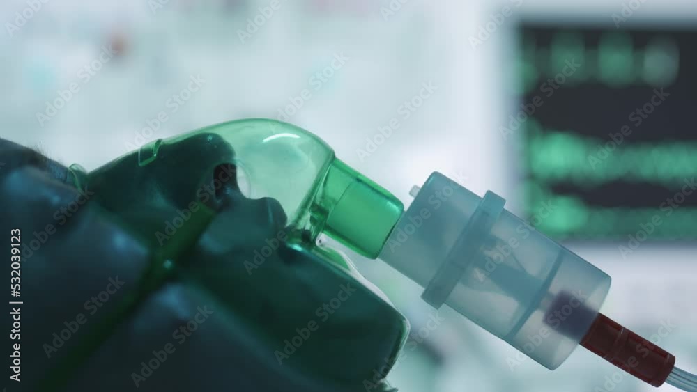 A female patient in medical mask is breathing oxygen support in a ...