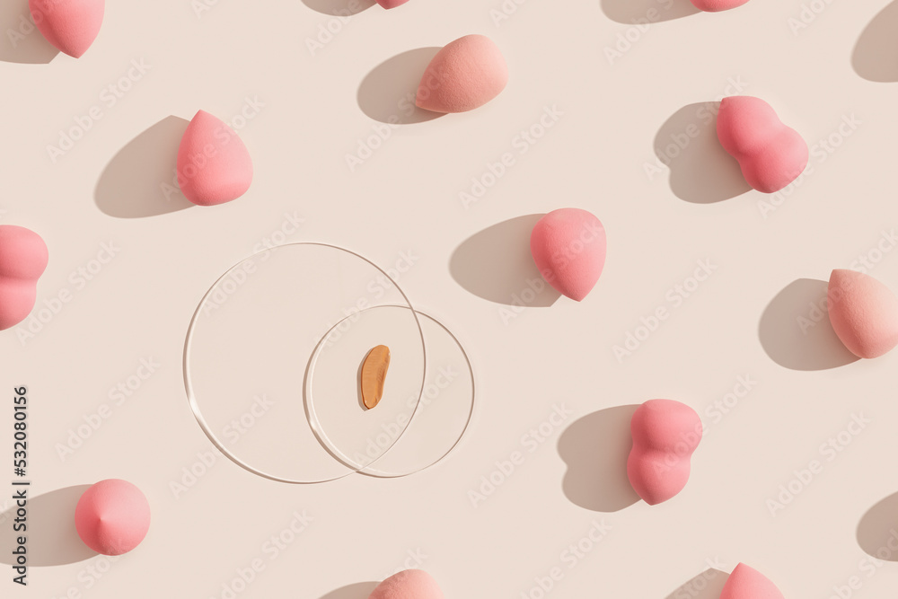 Makeup sponges for foundation cream, samples on glass disk on beige ...