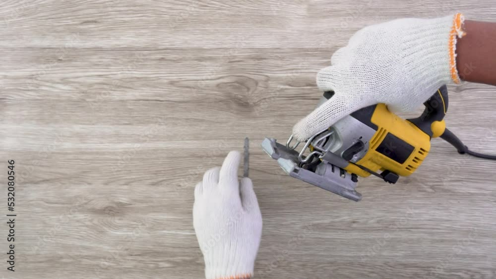 Two hand wearing white gloves inserting saw blade to yellow black jig ...